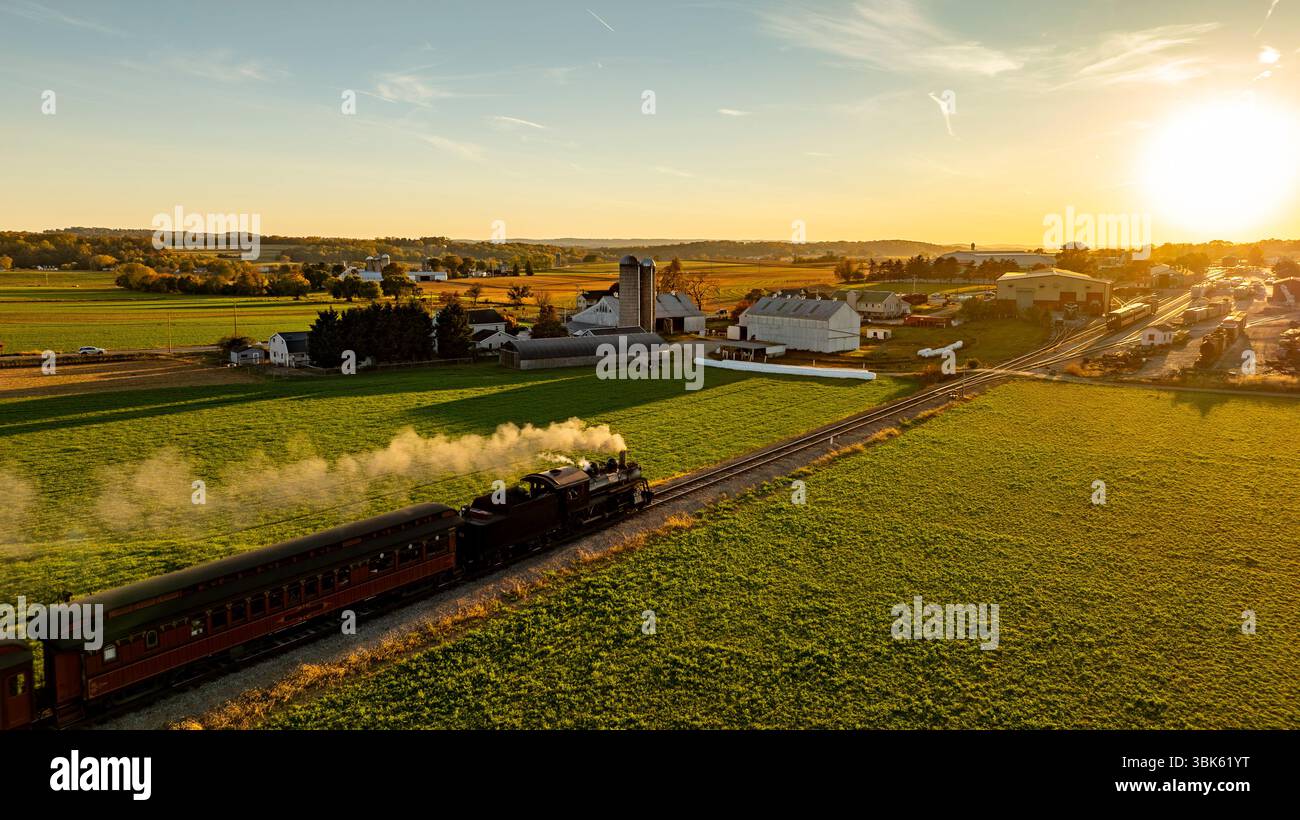 A vintage steam train moves along a scenic route surrounded by lush ...