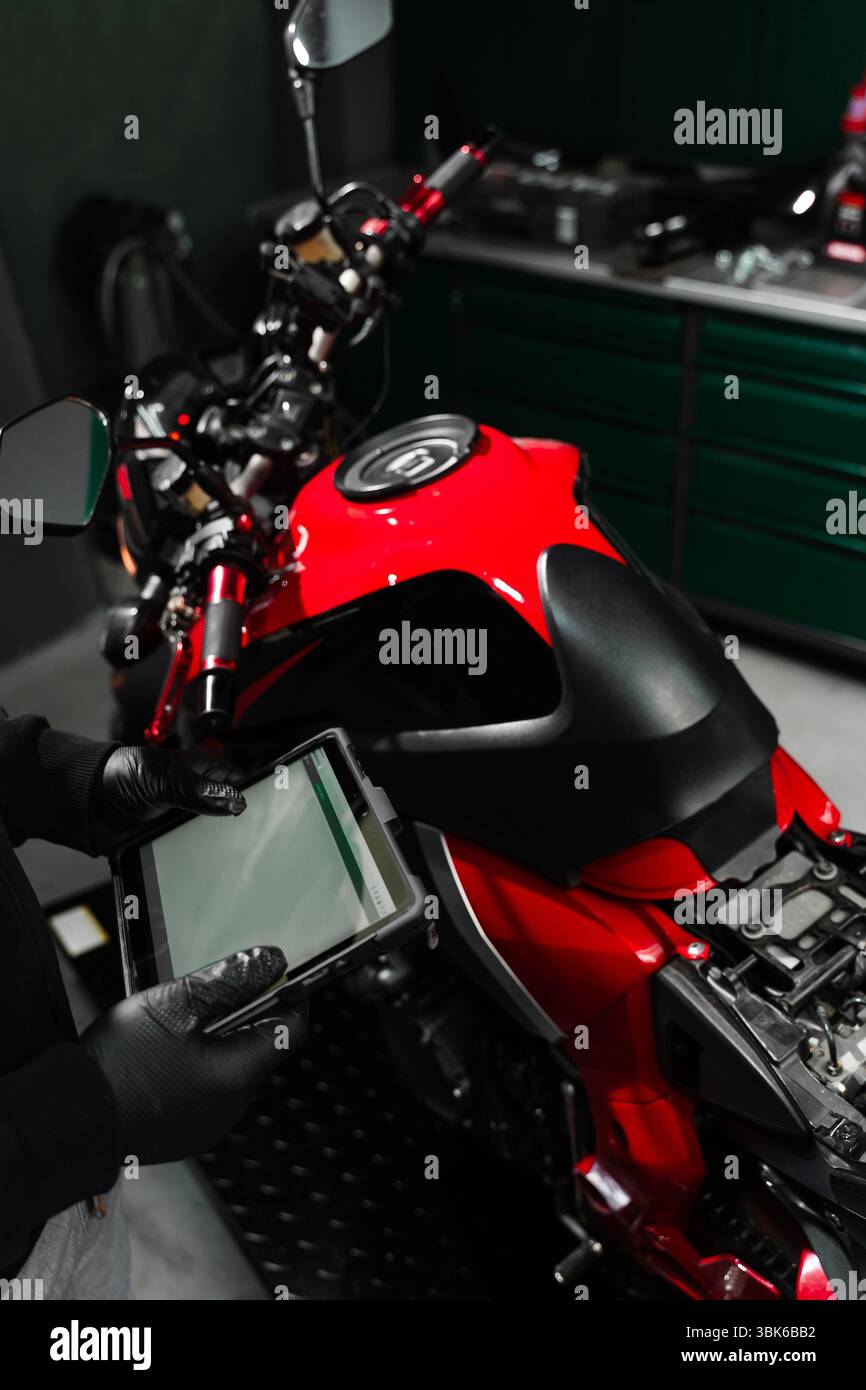 Mechanic performing system diagnostics via tablet. Motorcycle system ...