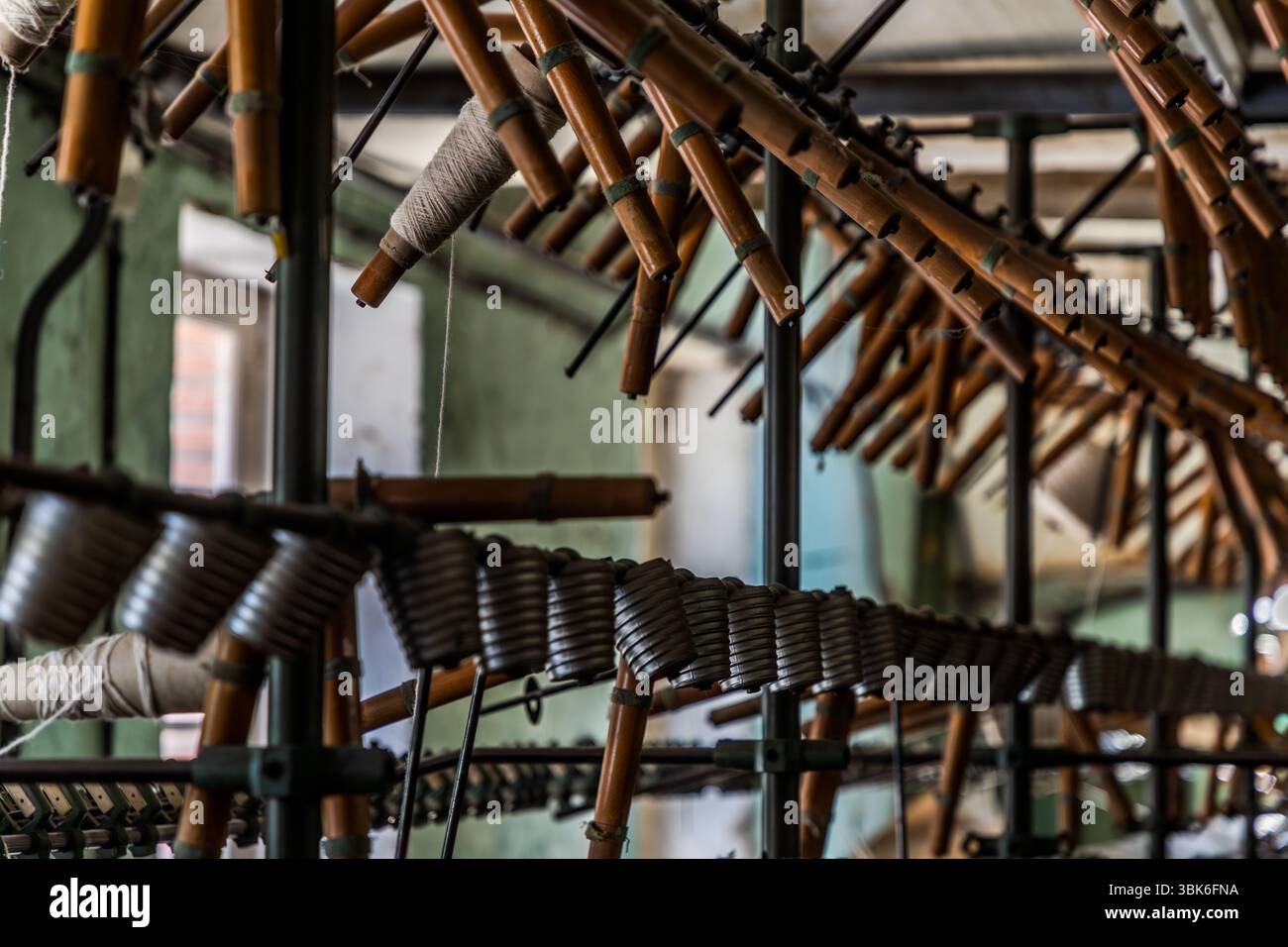 Close-up of spindles on a historic textile machine from the 1940s at ...