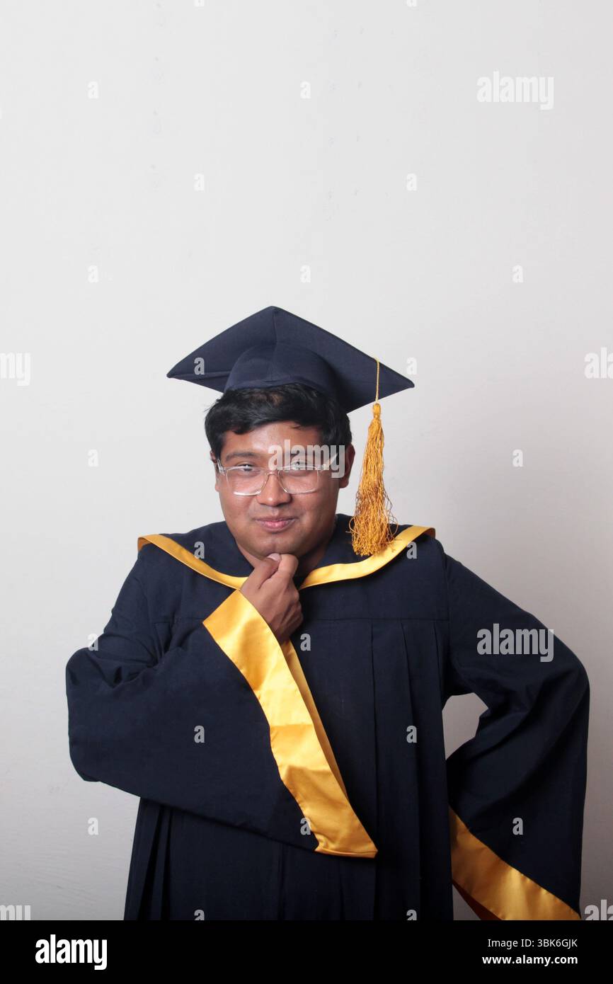 30-year-old dark-skinned Latino man with glasses wears a cap and gown ...