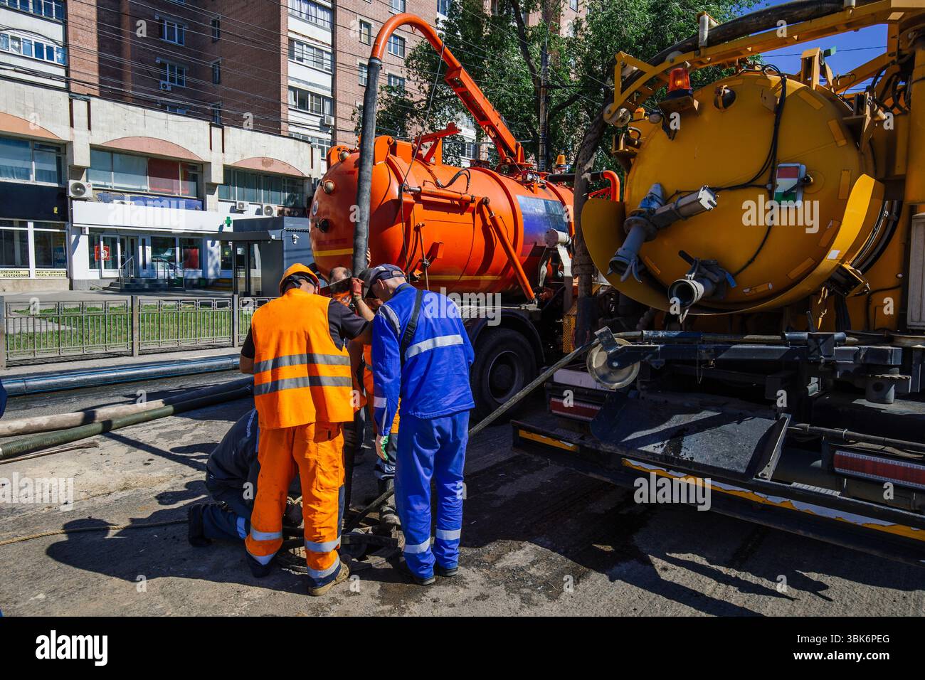 Workers cleaning sewer and pumping sewage into septic tank Stock Photo ...