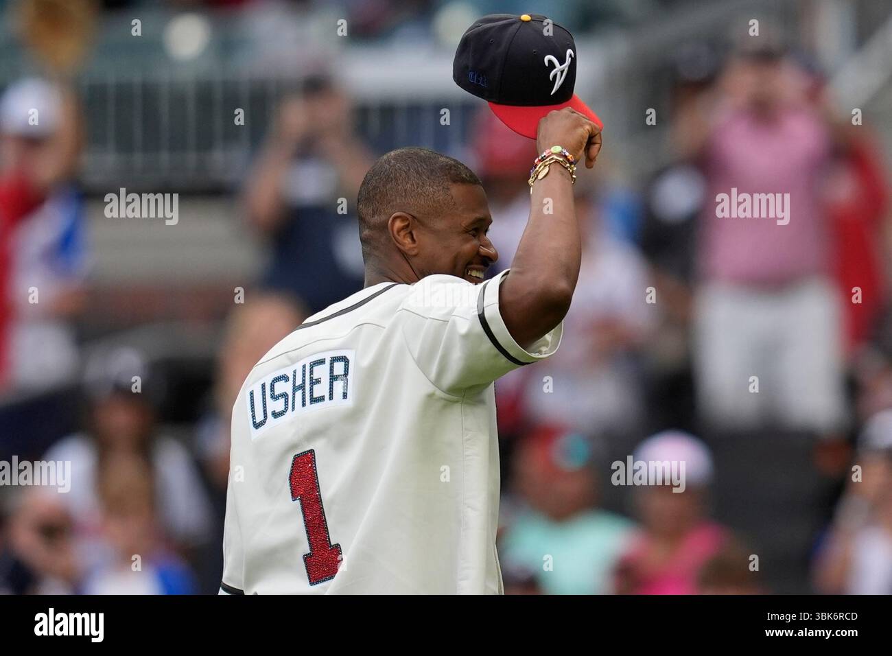 Entertainer Usher leaves the field after throwing the first pitch ...