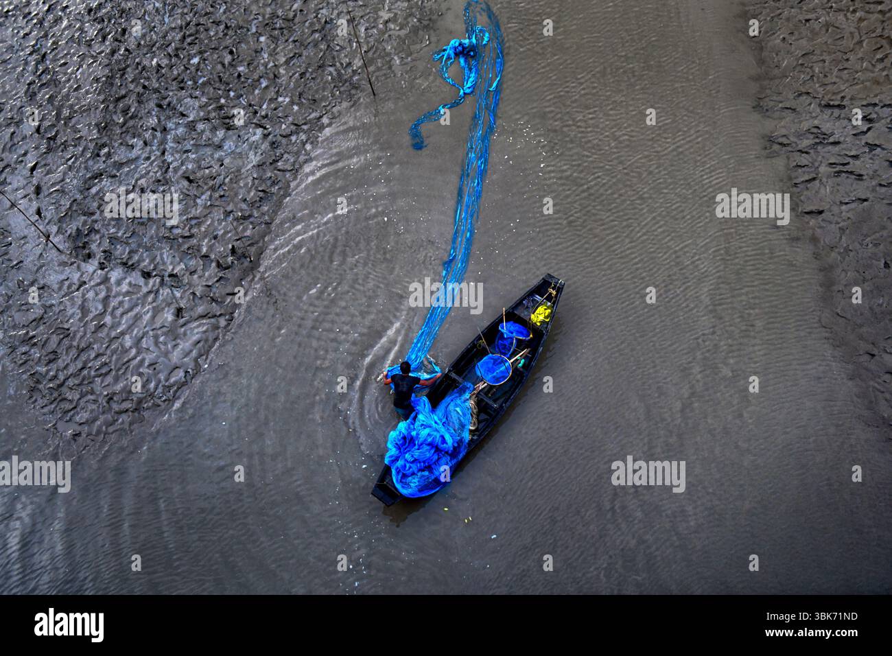 A fisherman seen winding up a fishing net after completion of his ...
