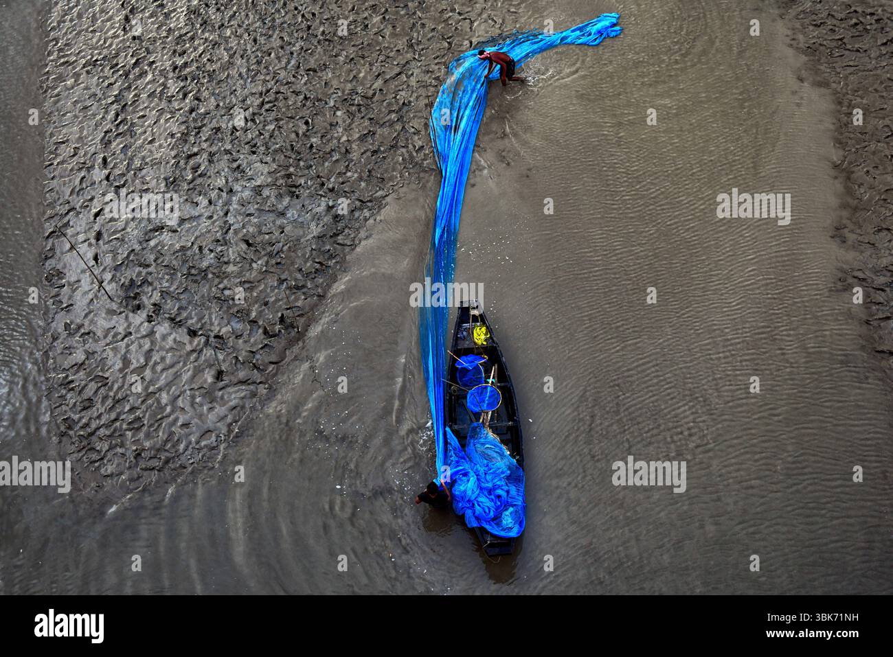 A fisherman seen winding up a fishing net after completion of his ...