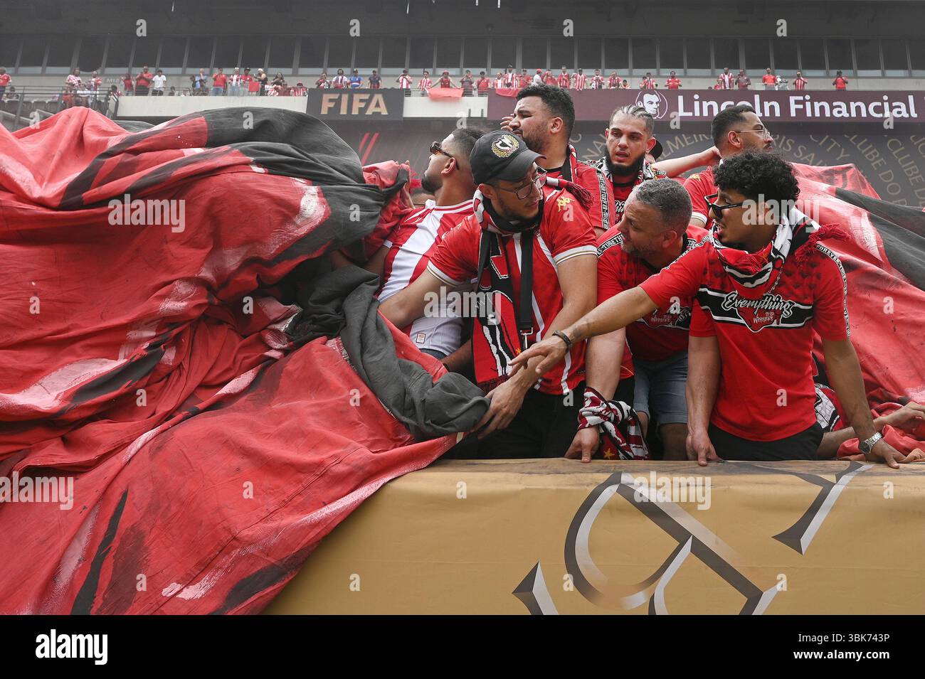 Philadelphia, USA. 18th June, 2025. Wydad AC supporters furl up a large ...