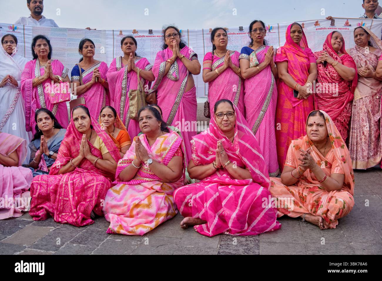 A group of sari-clad Jain women of the Digambara sect, hands folded in ...