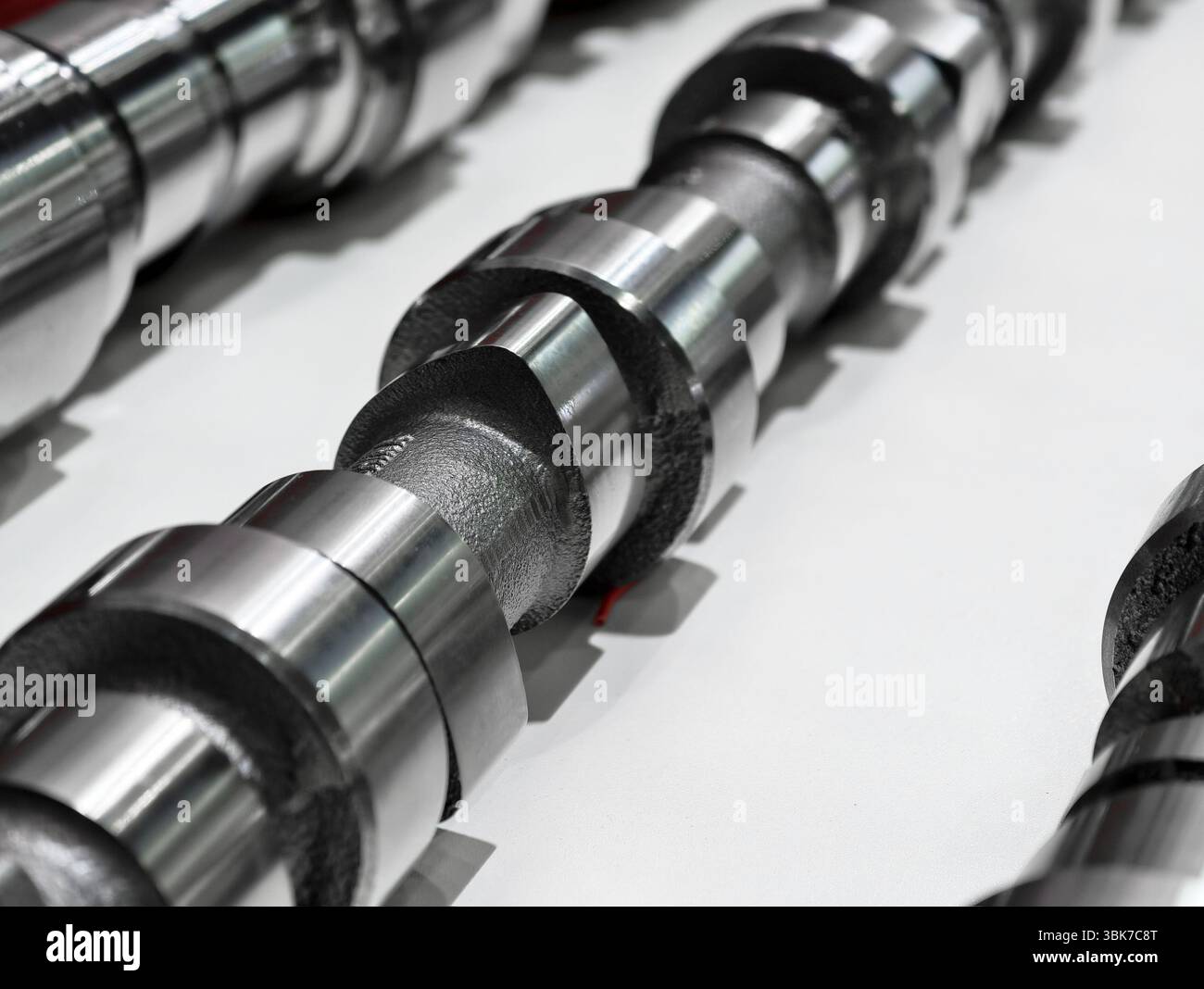 Close-up view of metallic camshafts on display in an automotive parts ...