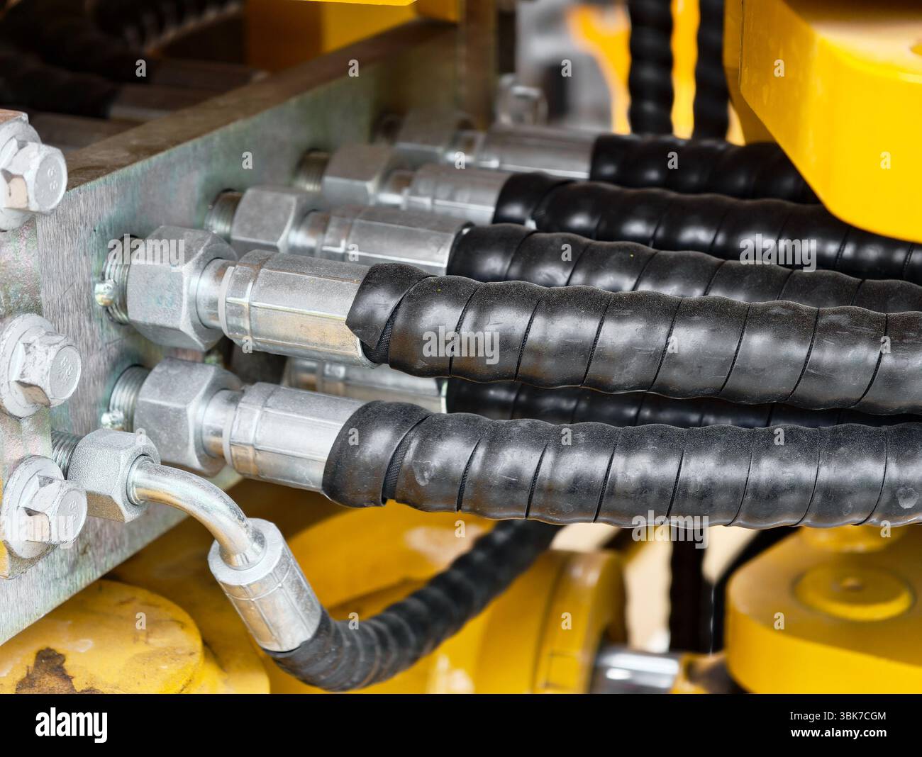 Hydraulic hose connections on heavy machinery in industrial setting ...