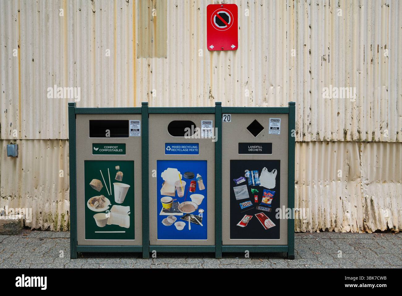 A recyling, compost & waste disposal bin beneath a 'No Parking' sign at ...