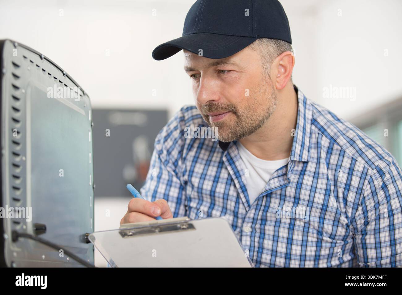 serviceman writing the appliance serial number on his paperwork Stock ...