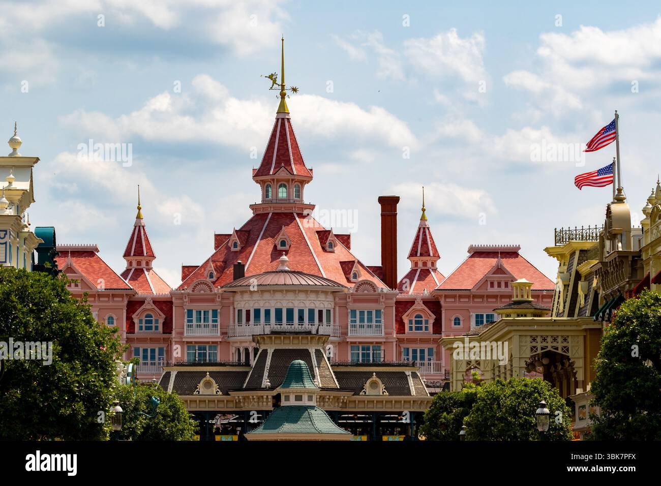Pink and red building with turrets and towers against a blue and cloudy ...