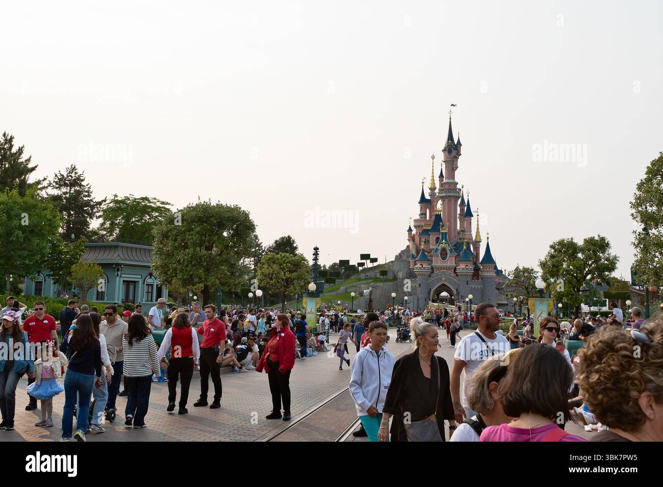 Crowd of people on a pathway with Sleeping Beauty's castle in the ...