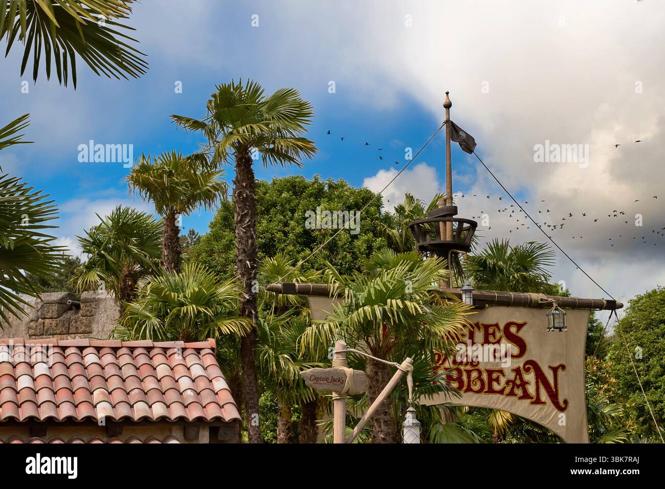 View of "Pirates of the Caribbean" ride entrance with palm trees, birds ...