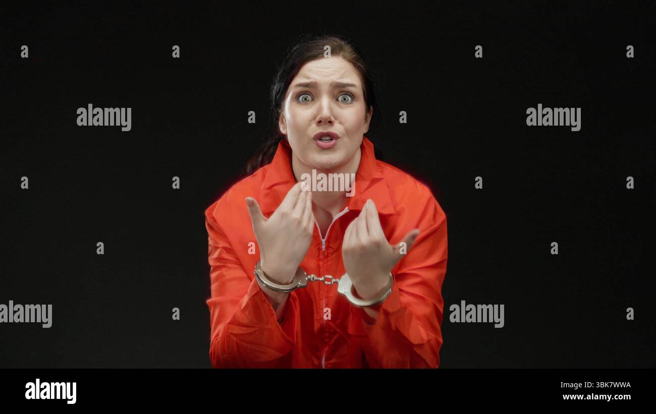 Woman in orange prison jumpsuit with handcuffs, brunette hair against ...