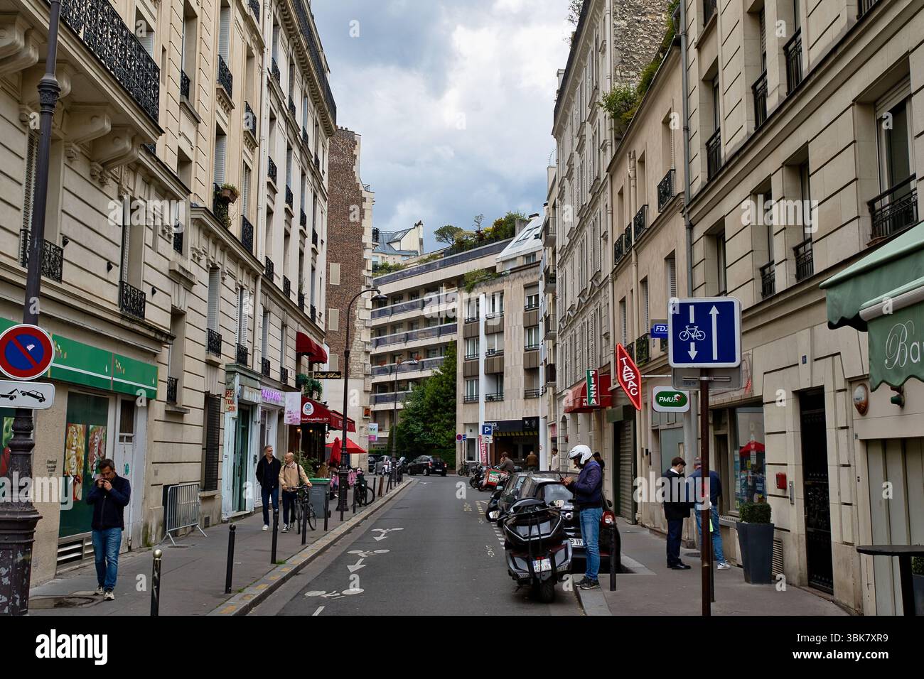 Street view in Paris, featuring buildings, parked vehicles, pedestrians ...