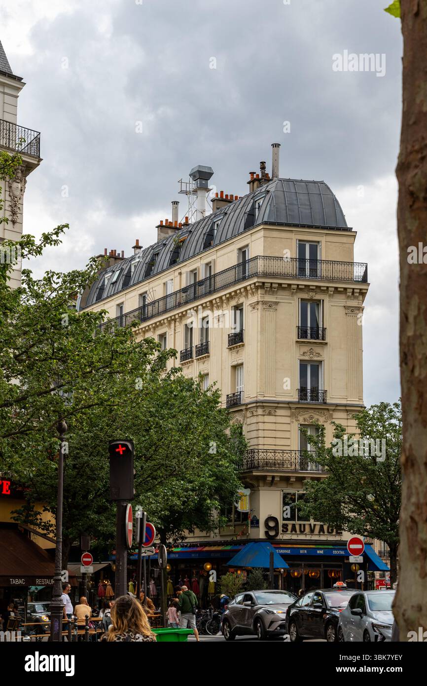 A street scene in Paris featuring a building with a curved roof, a ...