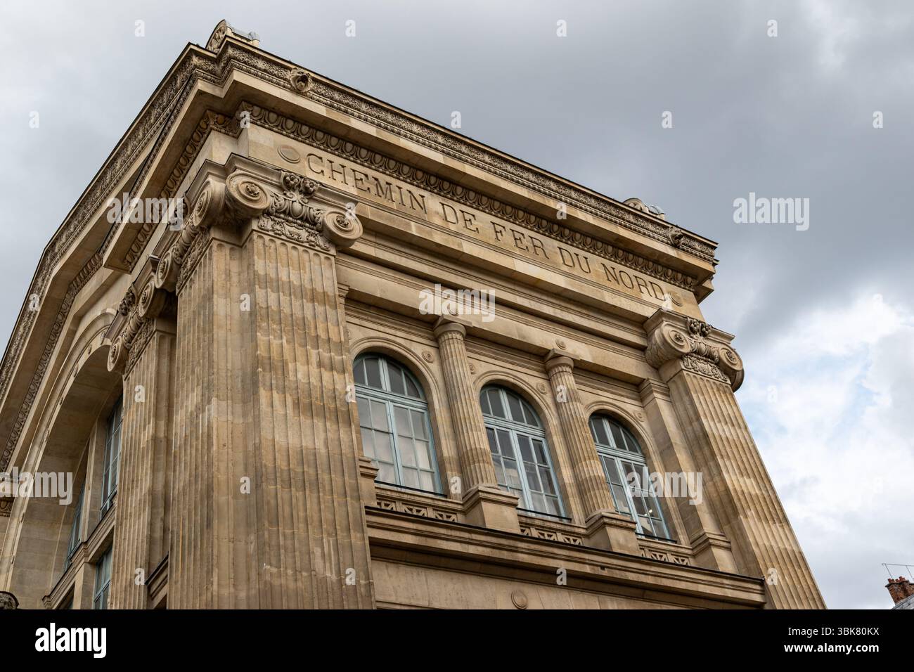 Low angle shot of building exterior with stone columns, arched windows ...