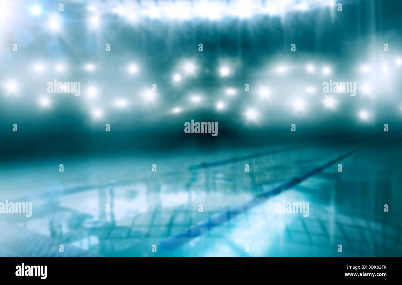 Empty pool lanes are reflecting overhead lights on clear water in flat ...