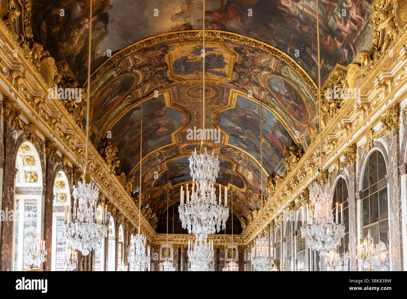 Ornate interior featuring a painted ceiling, chandeliers, and gilded ...