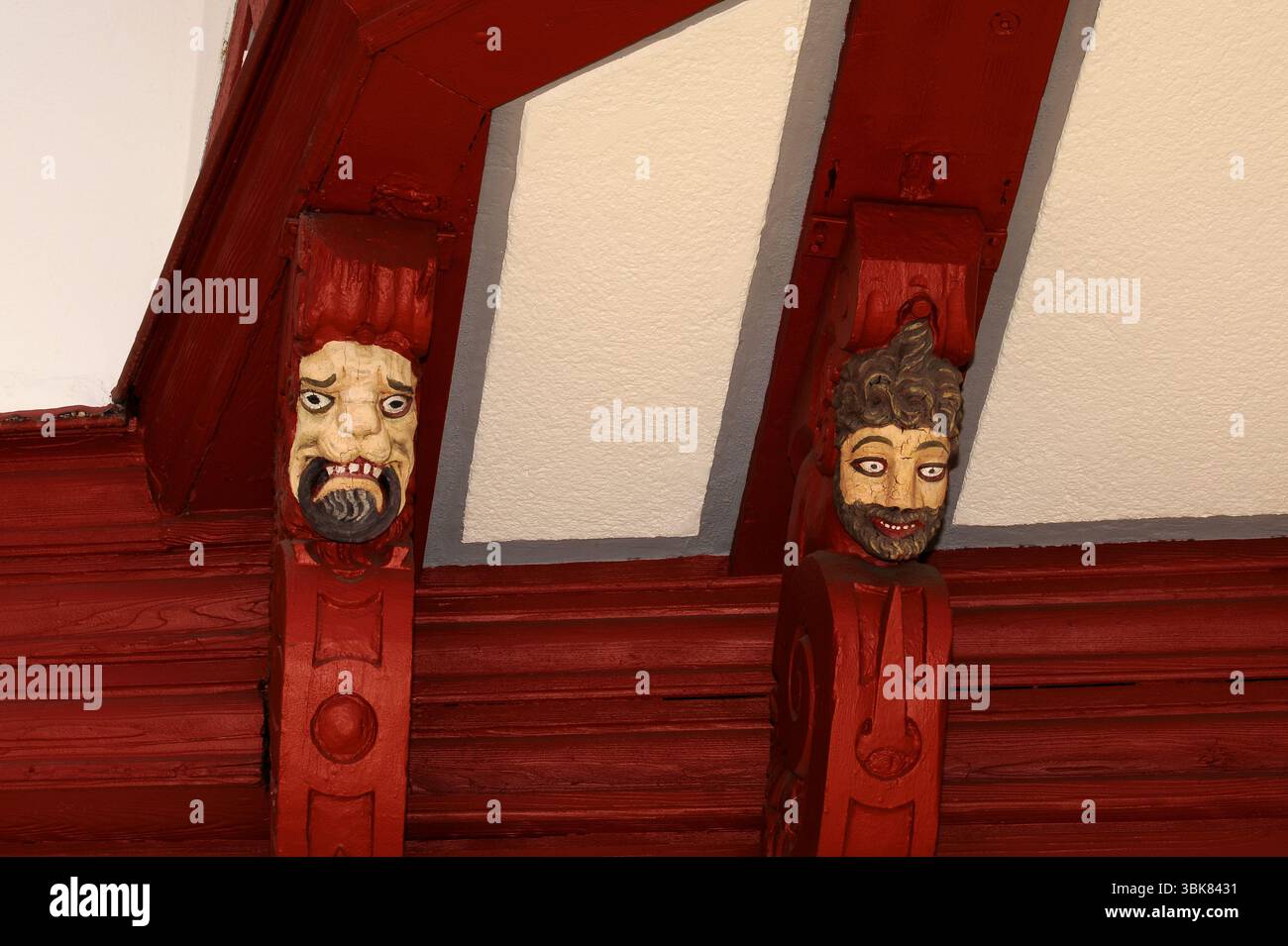 Two grotesque bearded faces grimace and grin on oak corbels supporting ...