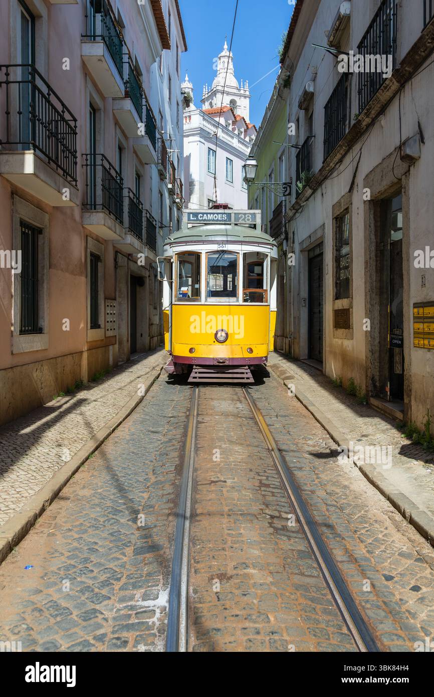 Iconic yellow tram on a narrow cobblestone street in Lisbon, Portugal ...