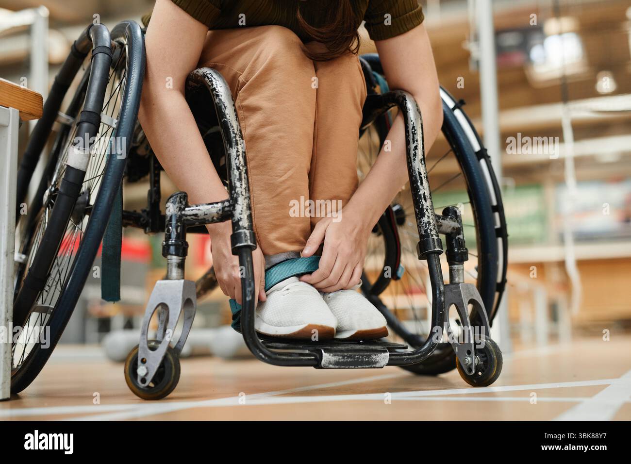 Woman Strapping Feet to Wheelchair Stock Photo - Alamy