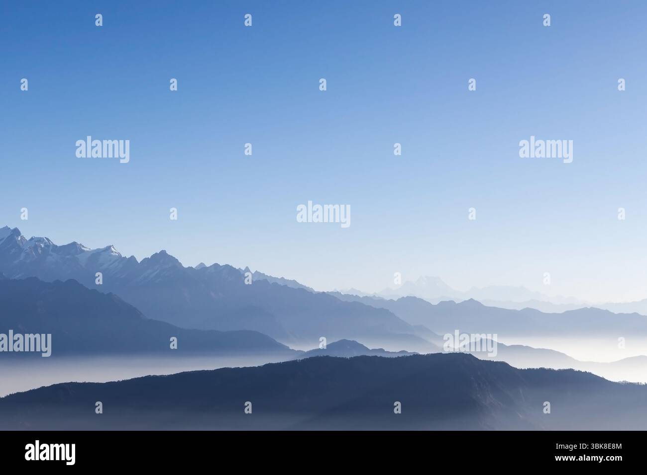 Foggy mountain range background with blue sky and white mist in the ...