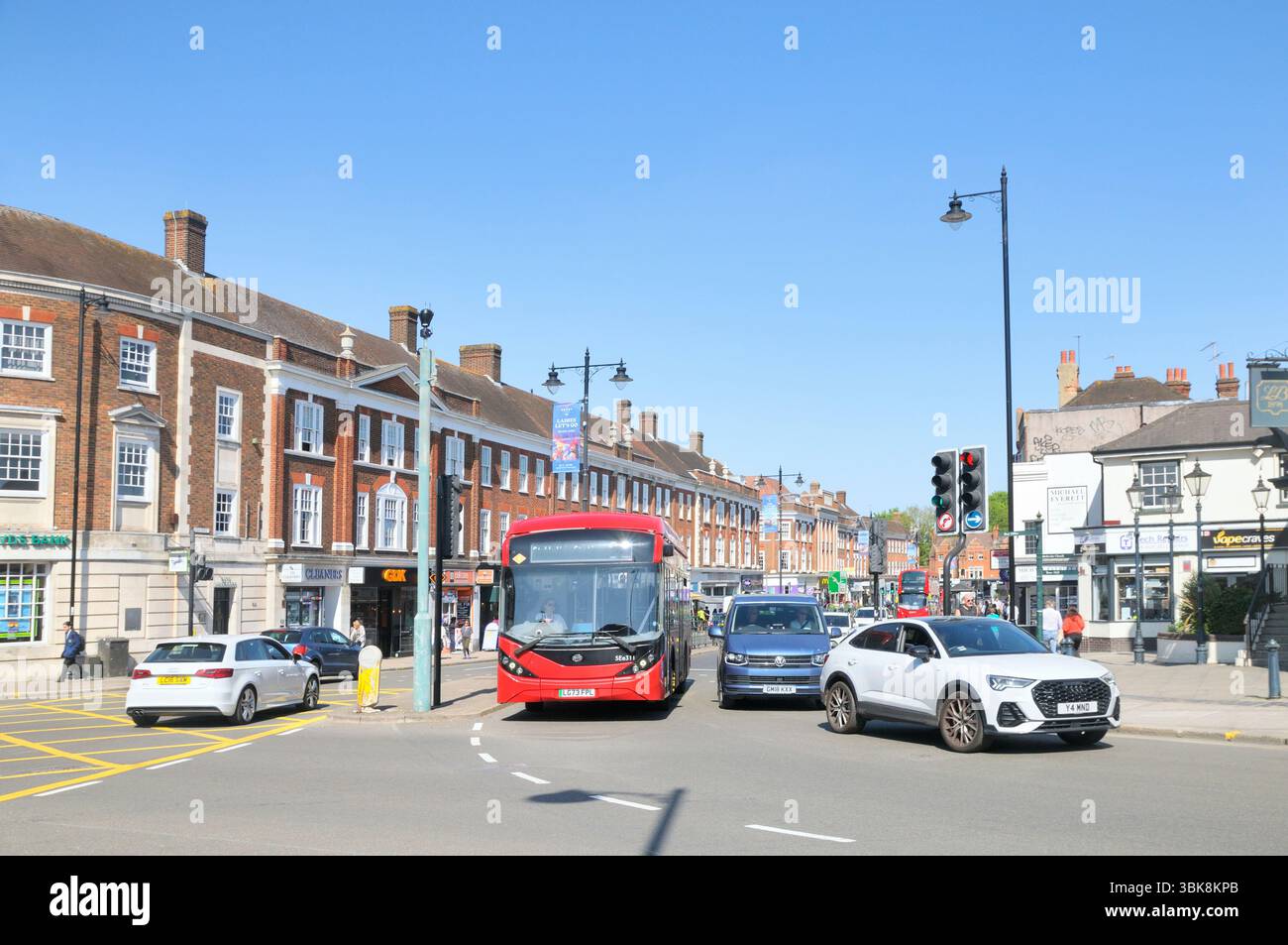 Epsom High Street and town centre with single decker red bus and other ...