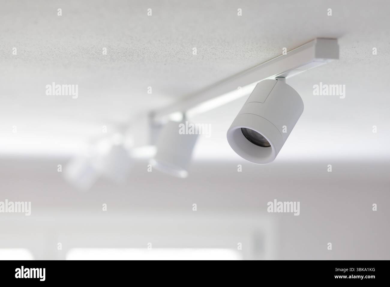 White spotlights hanging from a ceiling rail hi-res stock photography ...