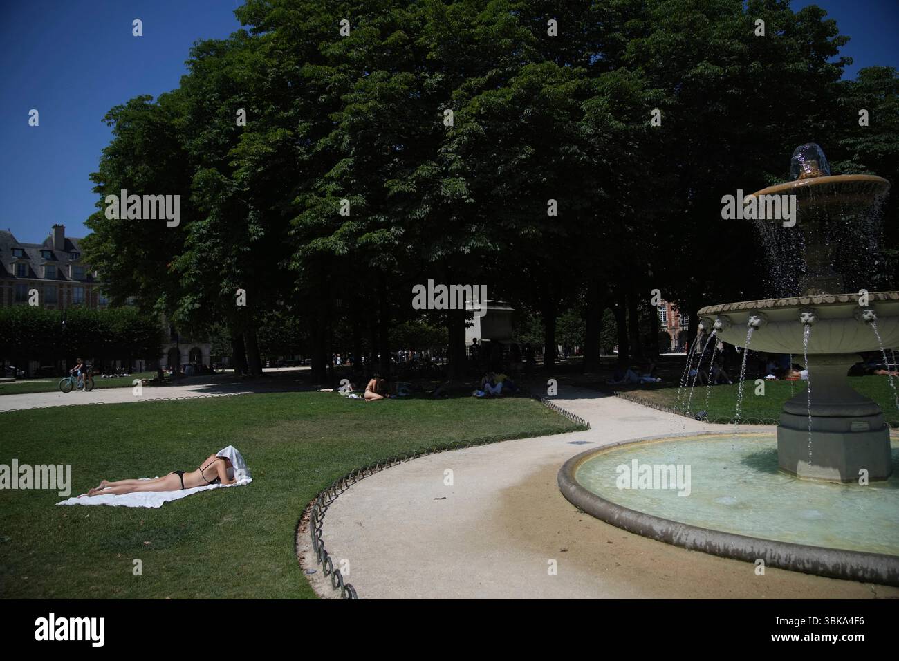 A woman sunbathes near a fountain as temperature rose up to 32 degrees ...