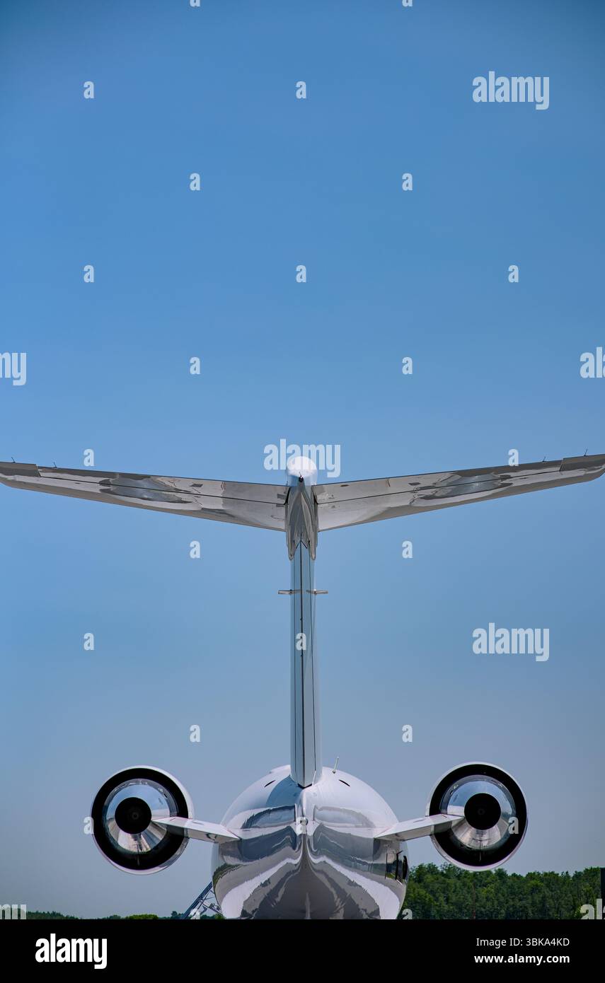 Vertical rear view of a business jet under a clear blue sky, showing ...