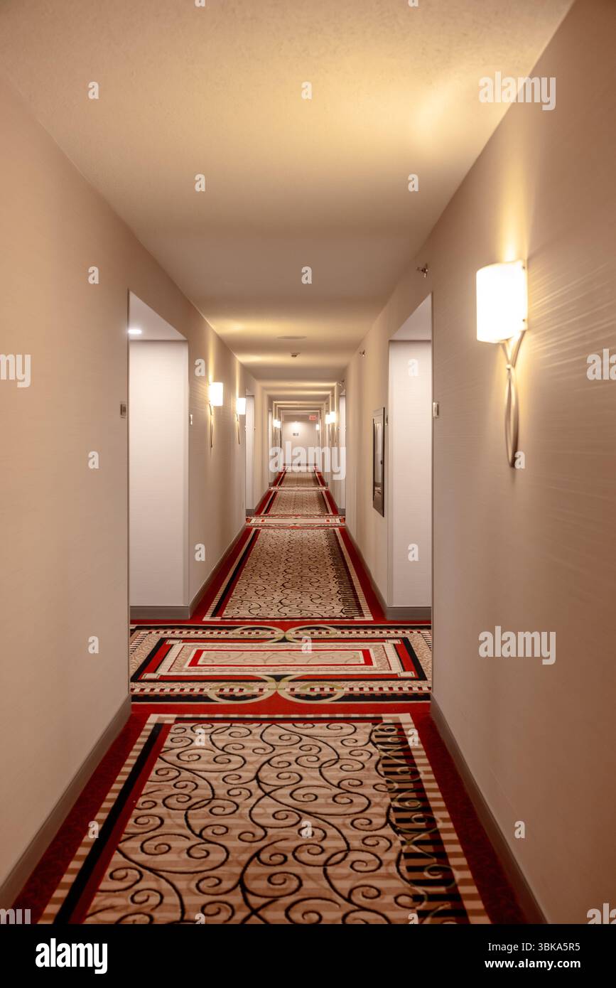 Long hotel corridor with red carpet angle shot Stock Photo - Alamy
