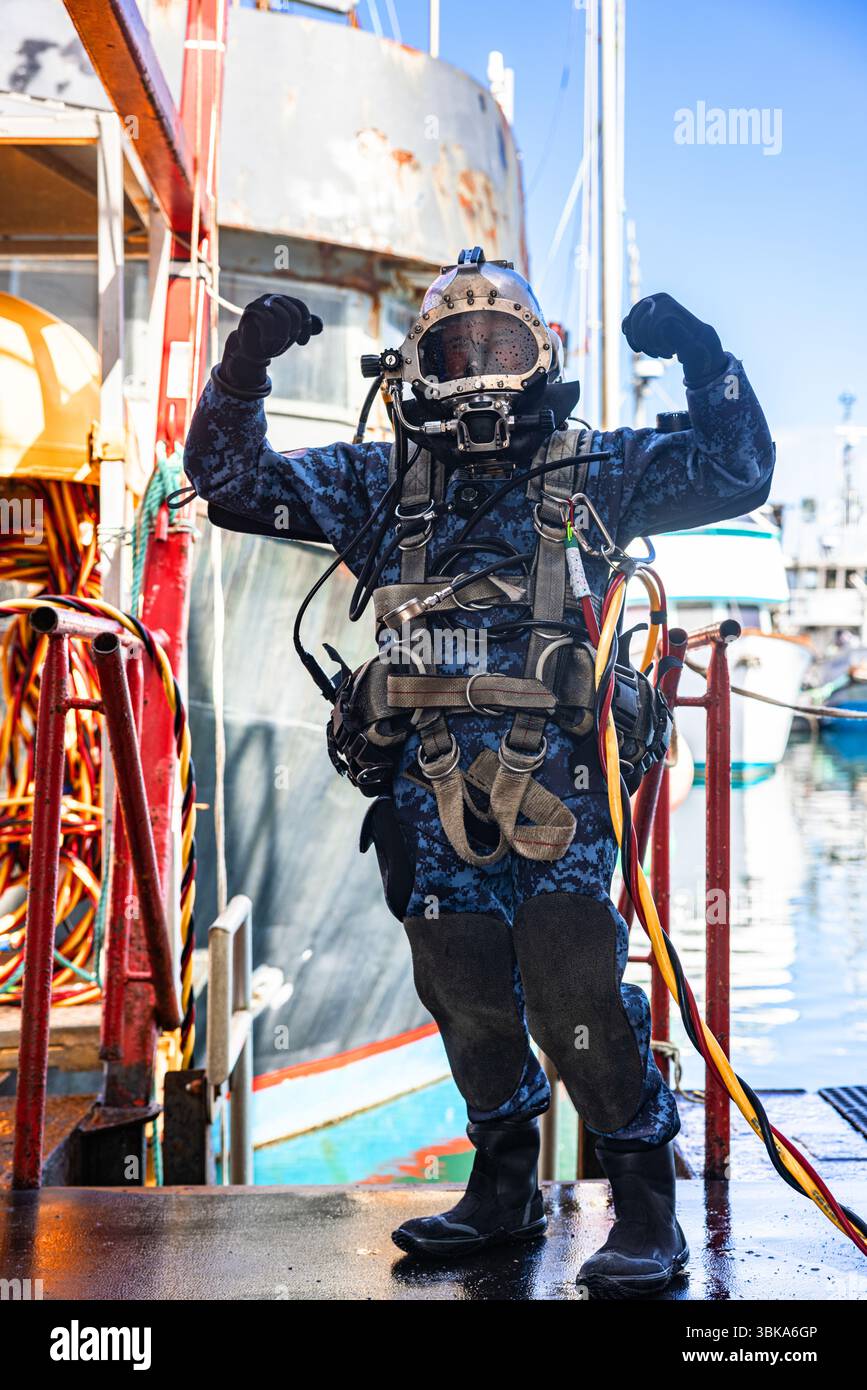 Commercial diver showing off after workshift in drysuit Stock Photo - Alamy