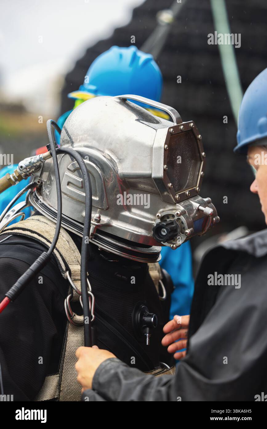 Commercial diver and tender prepare for dive closeup Stock Photo - Alamy