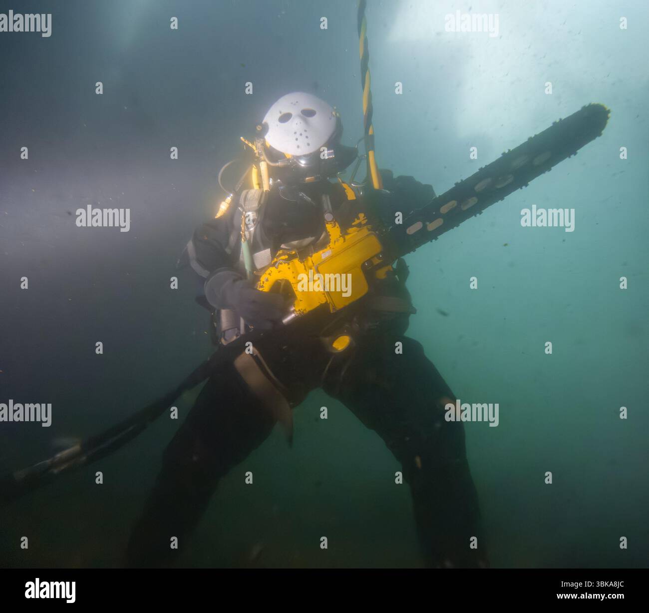 Commercial diver cutting log underwater with chainsaw closeup Stock ...