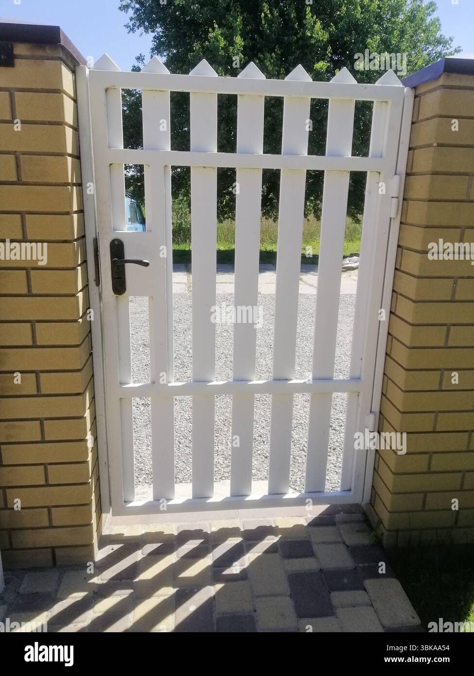 Modern white gate marks entrance to country yard. modern white secure ...