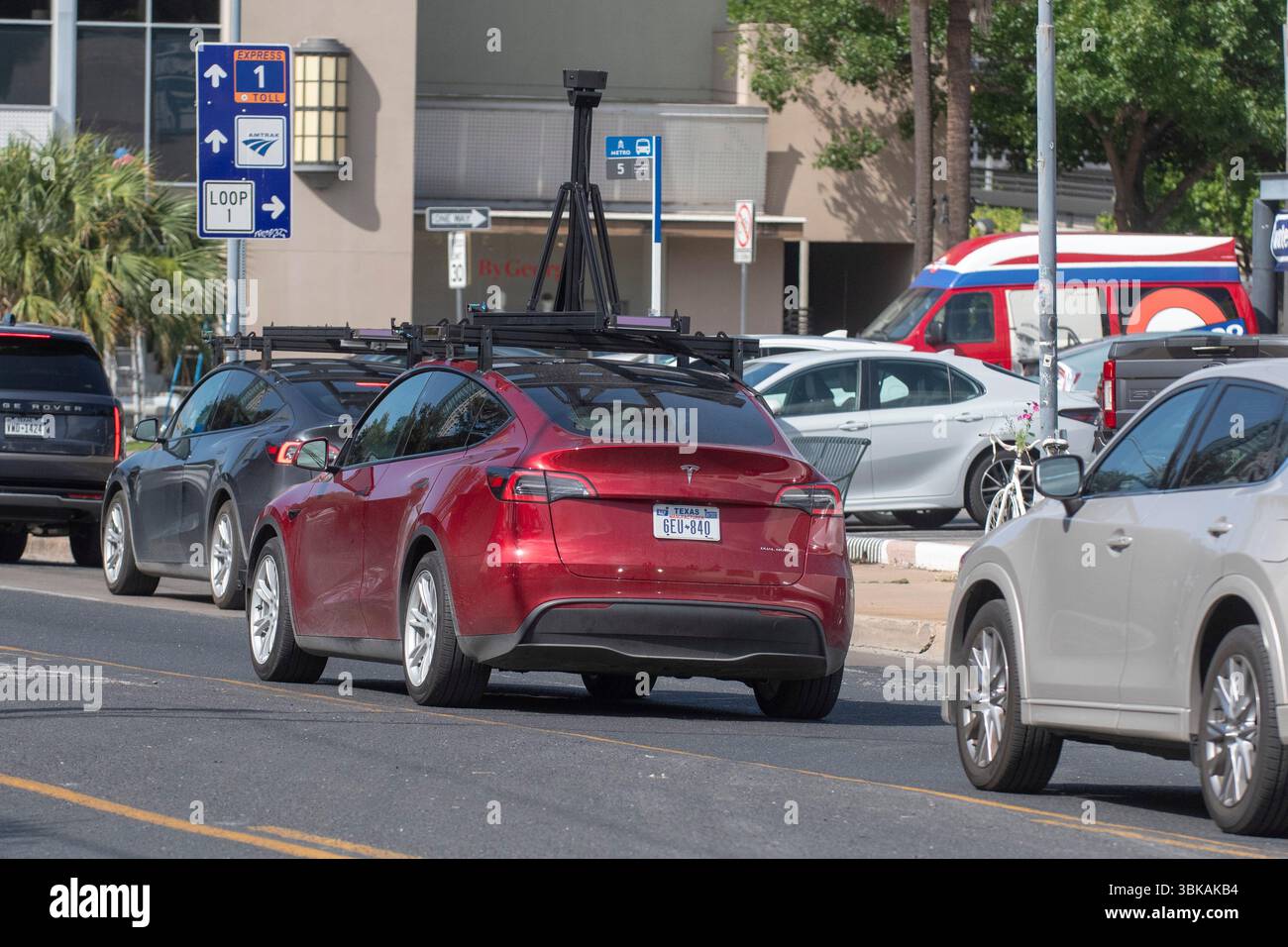 A Tesla Model Y electric car with special equipment on top drives down ...