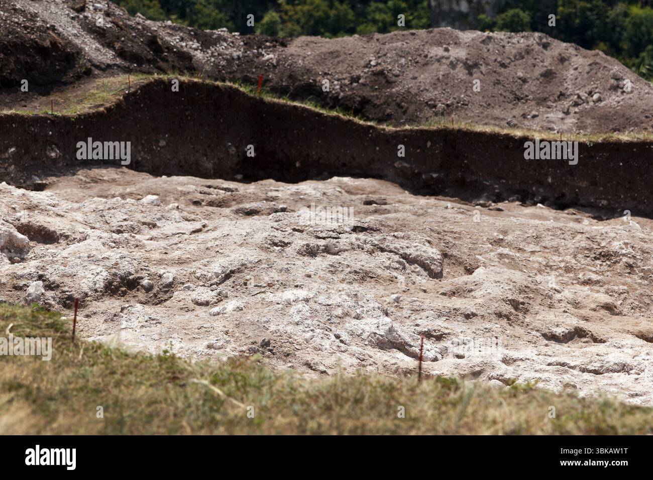 Exposed archaeological dig site showing soil layers and chalky surface ...