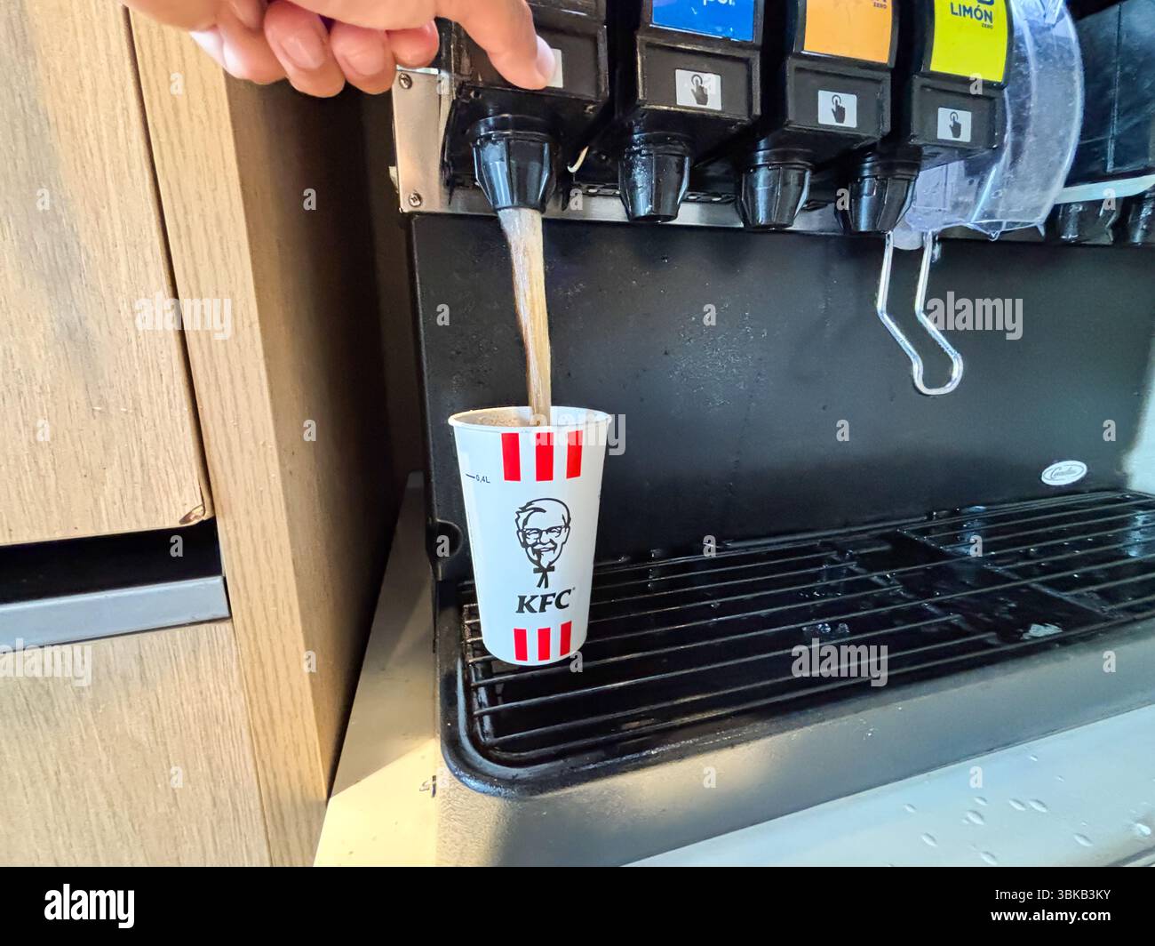 Alicante, Spain - June 18, 2025: Hand is filling KFC cup with soft ...