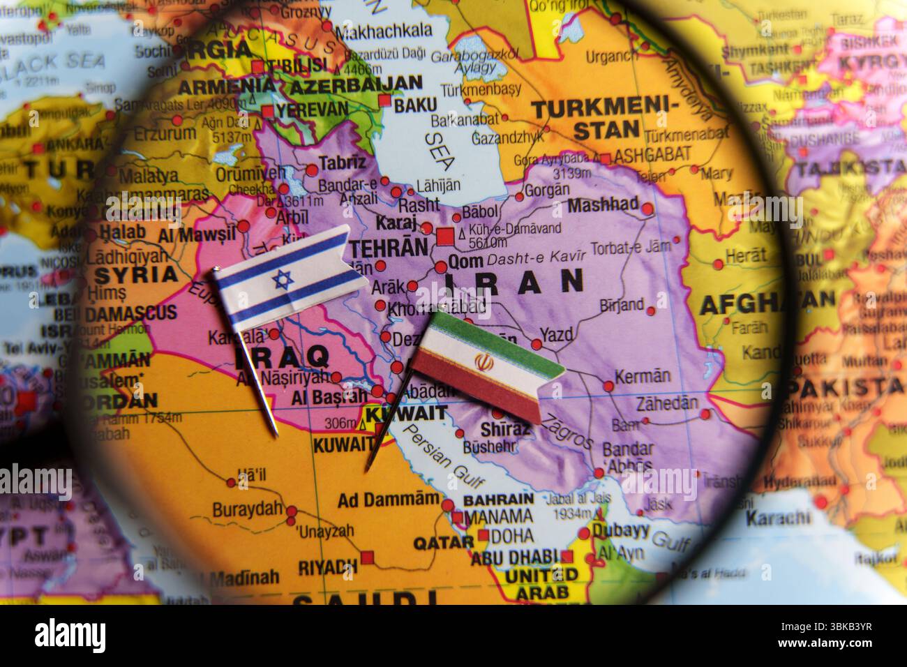Magnifying glass focusing on Iran with Iranian and Israeli flags on the ...