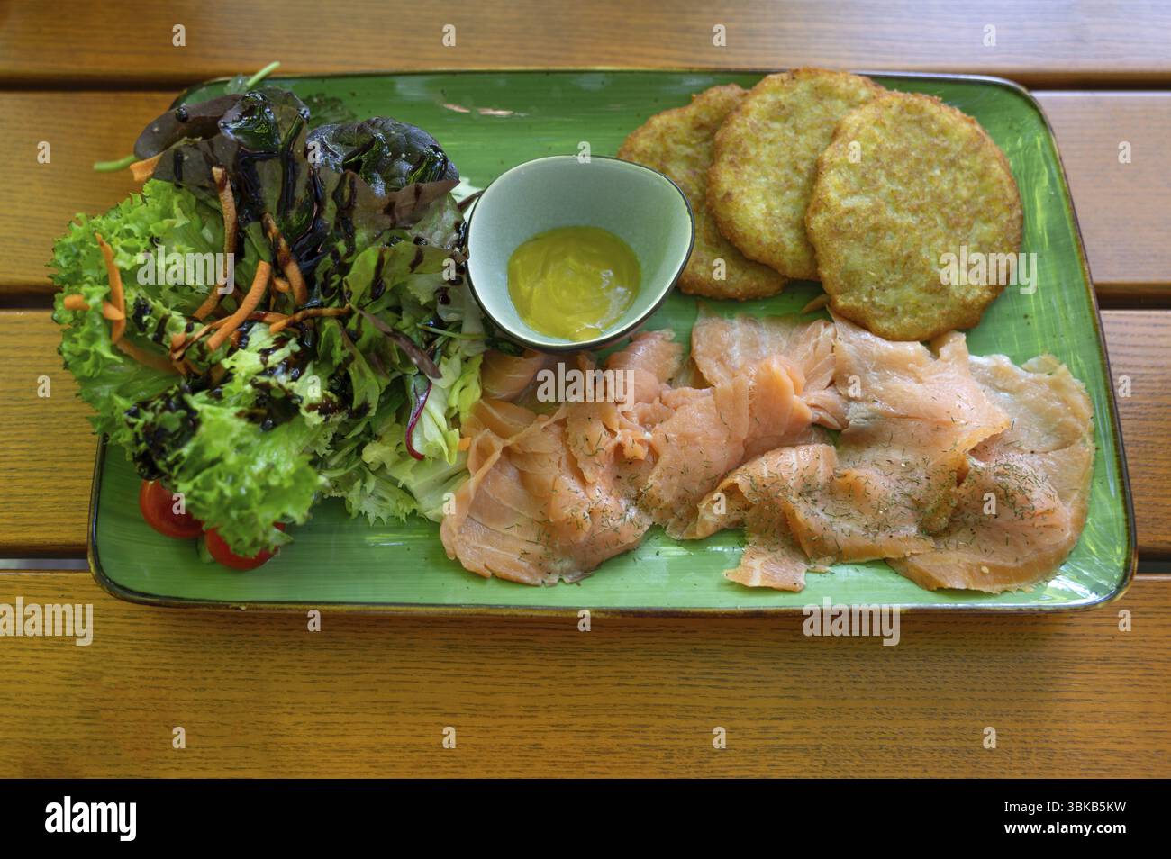 Salmon with baggers, potato pancakes and salad, served in a beer garden ...