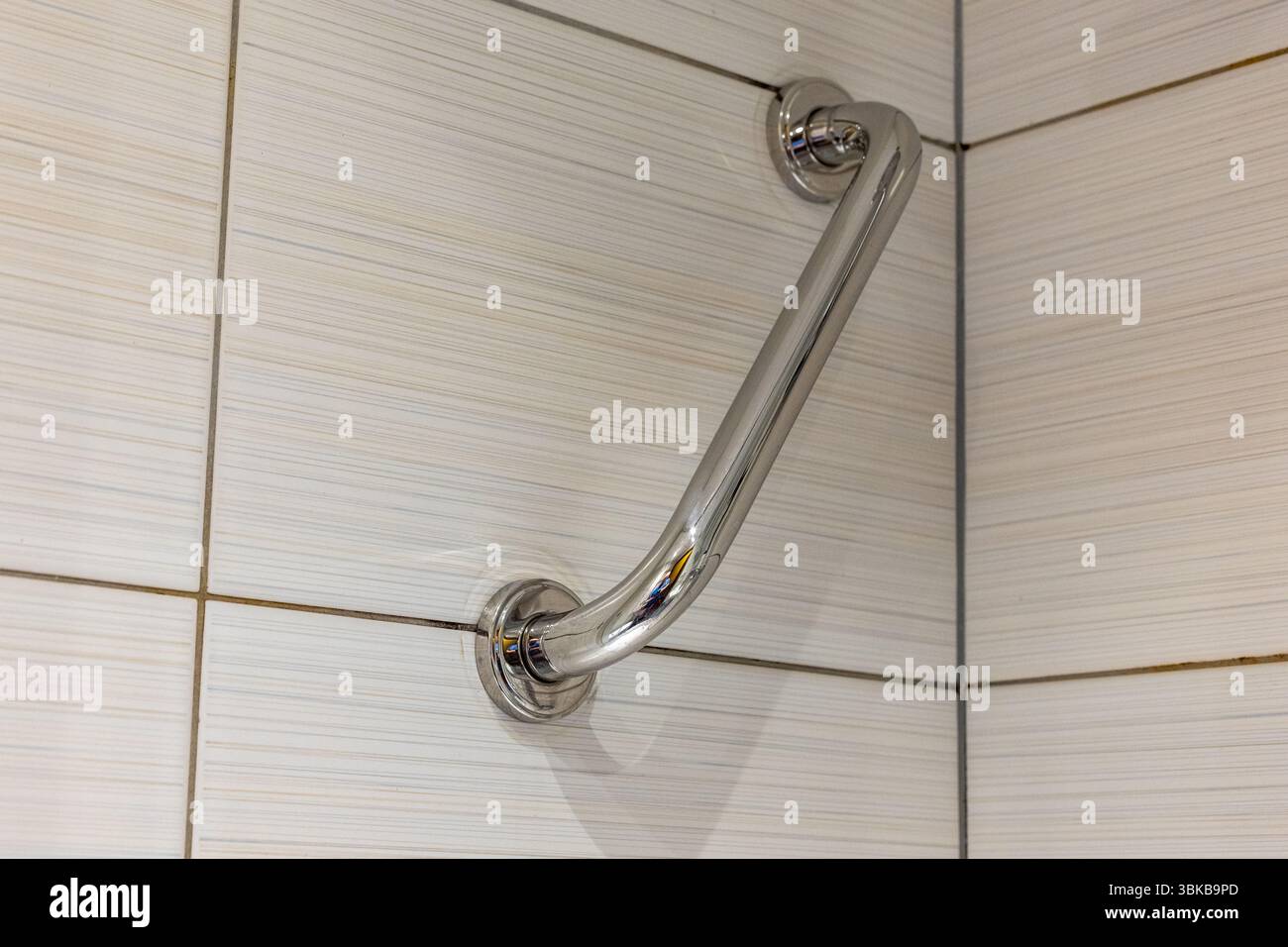 Chrome bathroom handle mounted on the wall inside the shower cubicle ...
