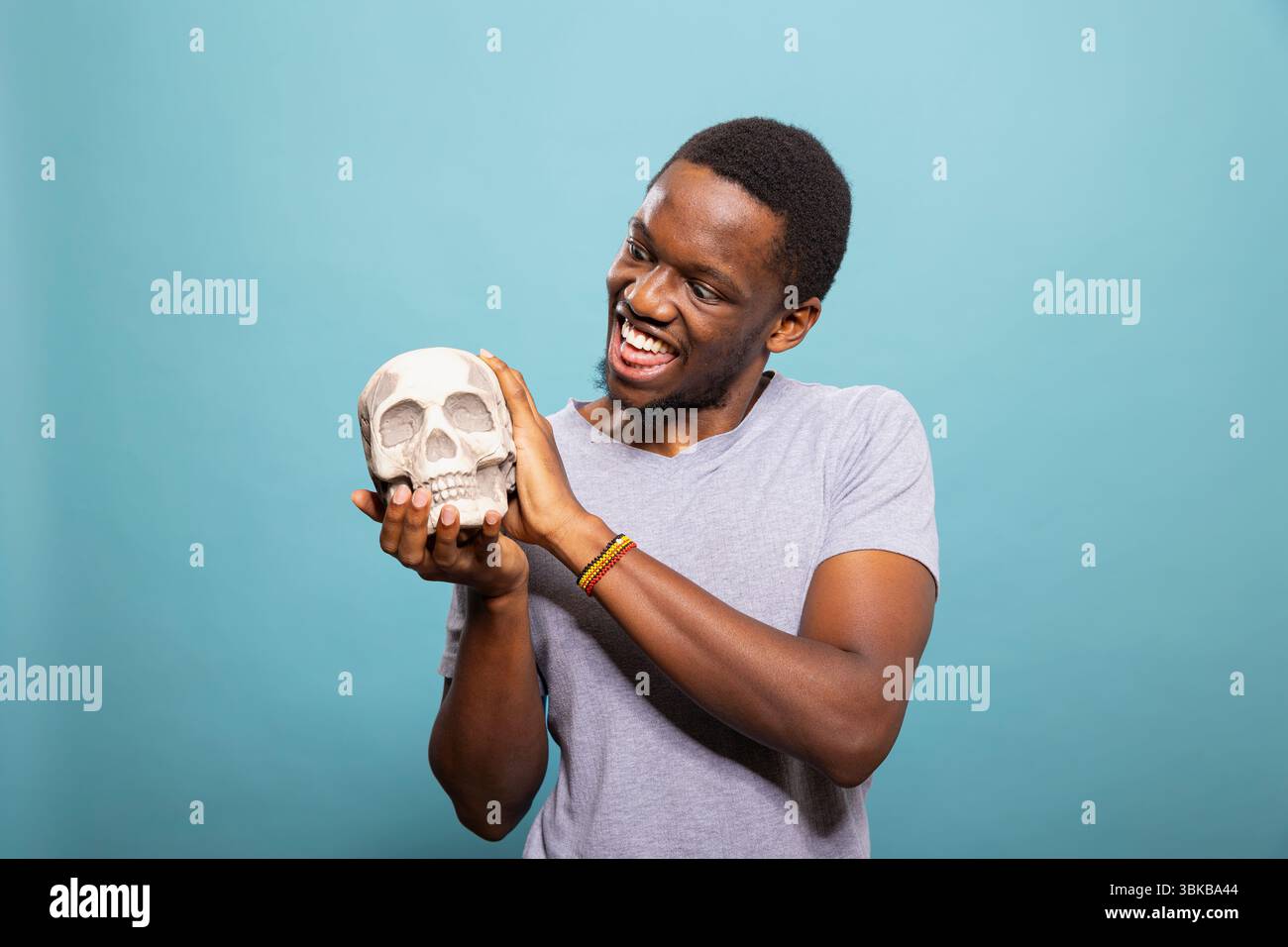 African American individual playfully interacting with a skeletal head ...