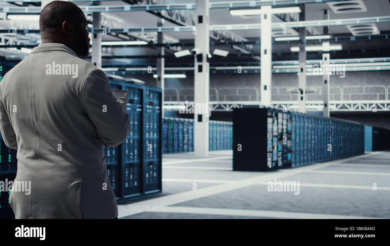 Engineer walking in data center using device to configure hardware ...