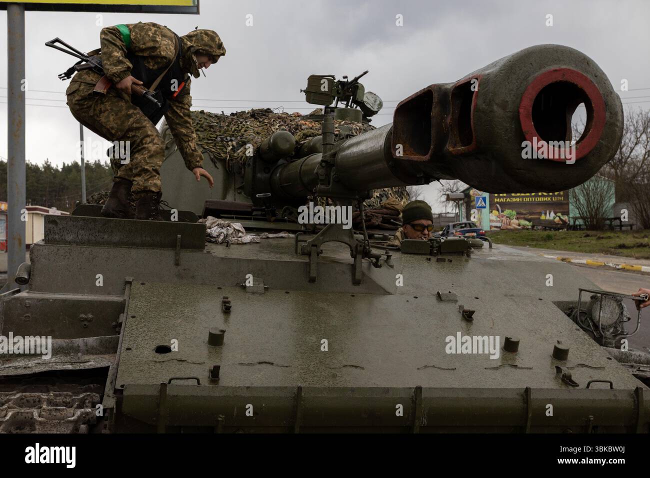 Soldiers stand on a military tank in a conflict-affected area ...