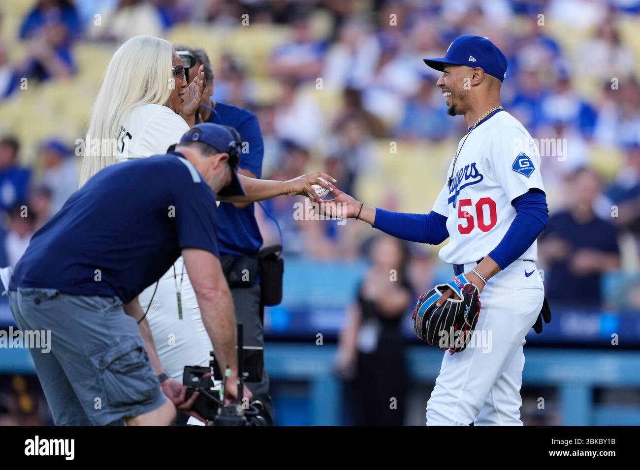 Lizzo gets a ball from Los Angeles Dodgers' Mookie Betts after throwing ...