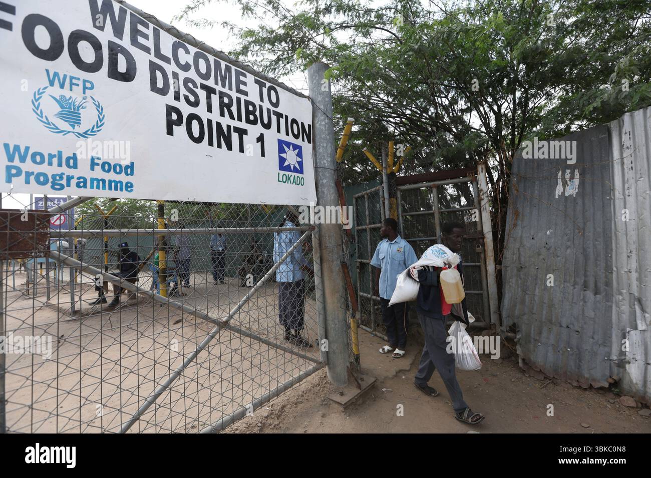 Refugees carry food at a distribution center run by the World Food ...
