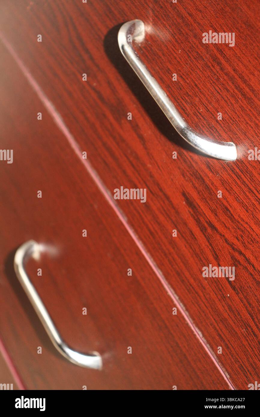 A close-up view of two sleek, metallic silver handles attached to the ...