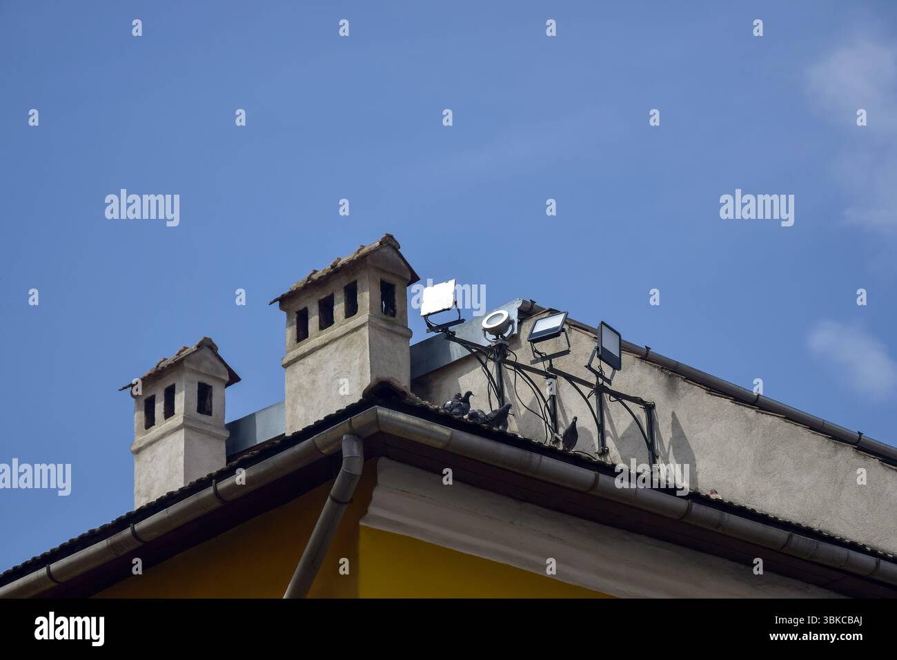 Floodlights installed on roof of old building with ventilation columns ...