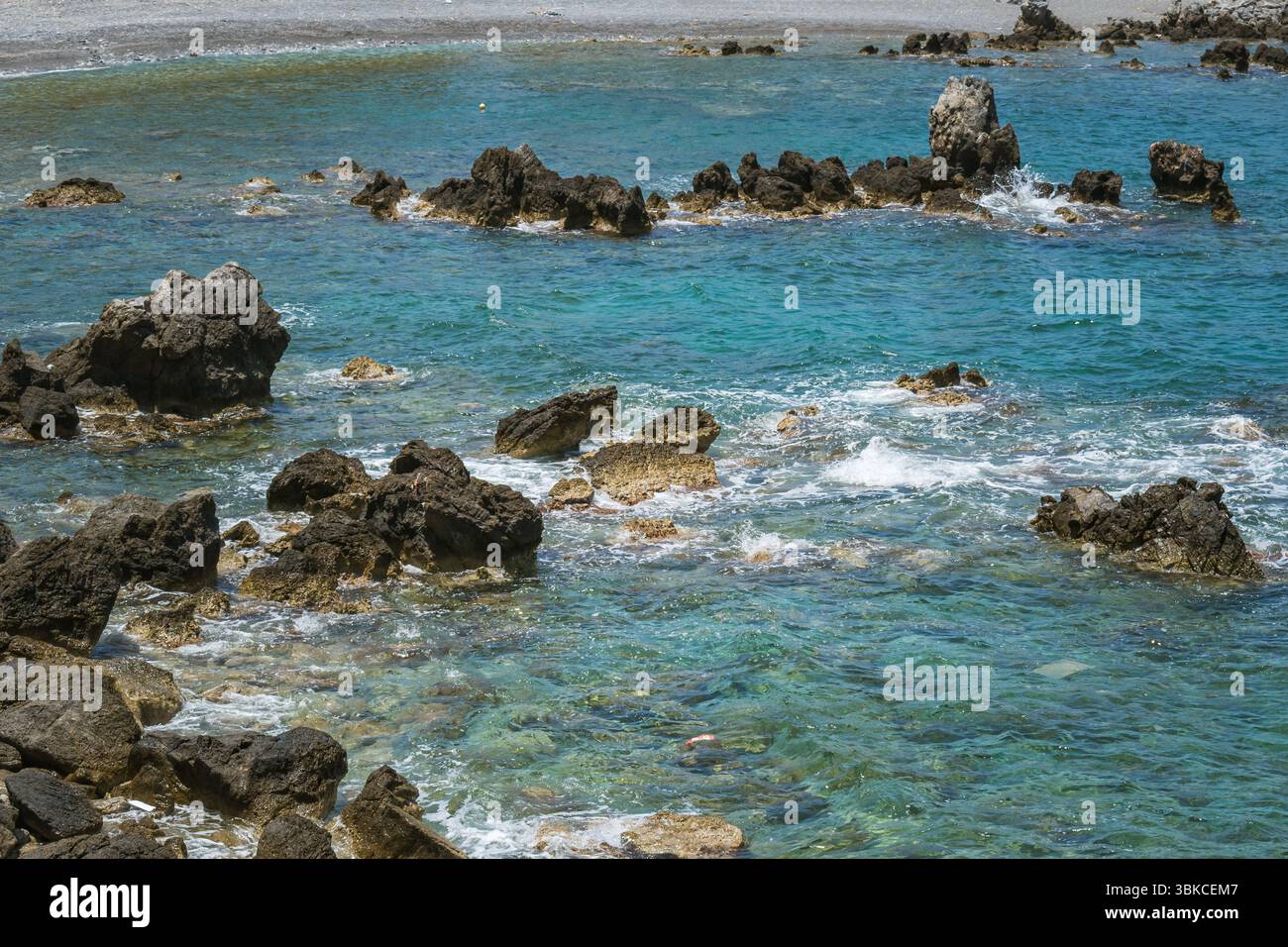 Greek beach in Crete island with clear water and massive stones ...